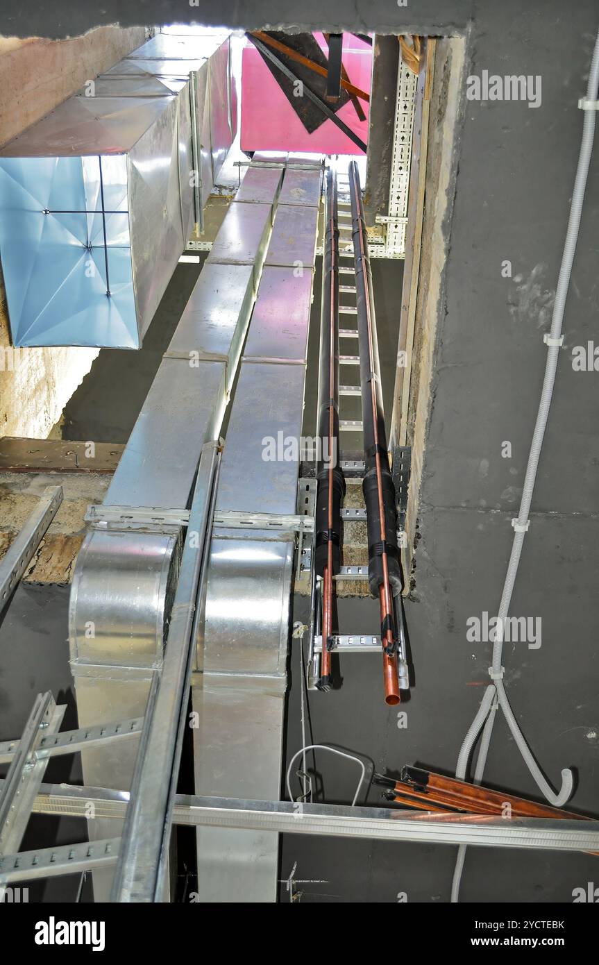Detailed view of electrical cable trays and ventilation ducts through a ...