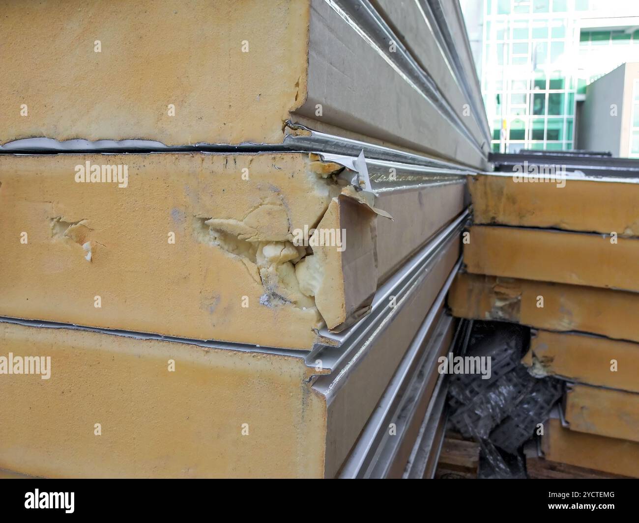Pile of PUR-insulated sandwich panels showing damage from handling on a ...