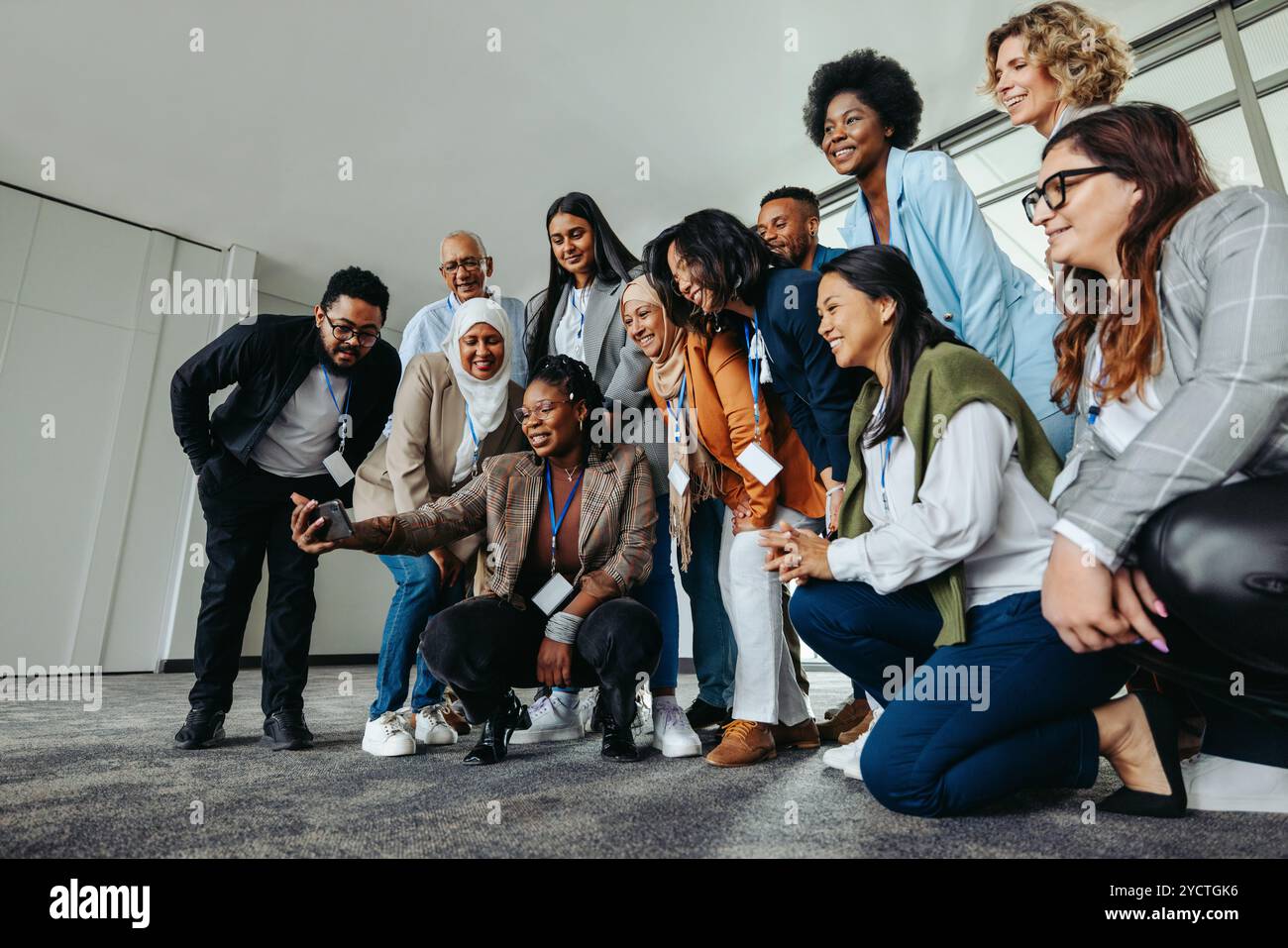 Multiethnic group of smiling businesspeople taking a group photo at a ...