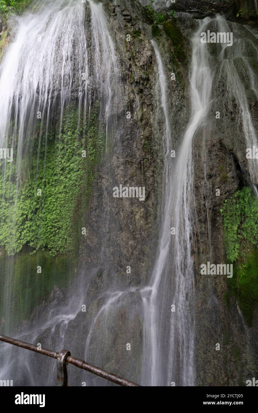 Small waterfall cascading against mountain rocks Stock Photo - Alamy