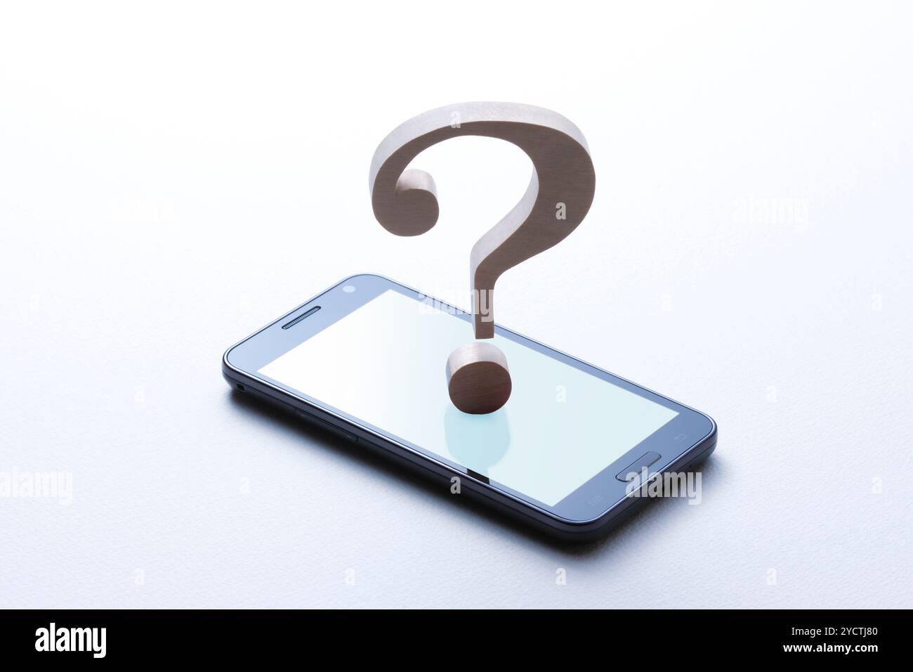 Smartphone and carved wooden question mark symbol Stock Photo - Alamy