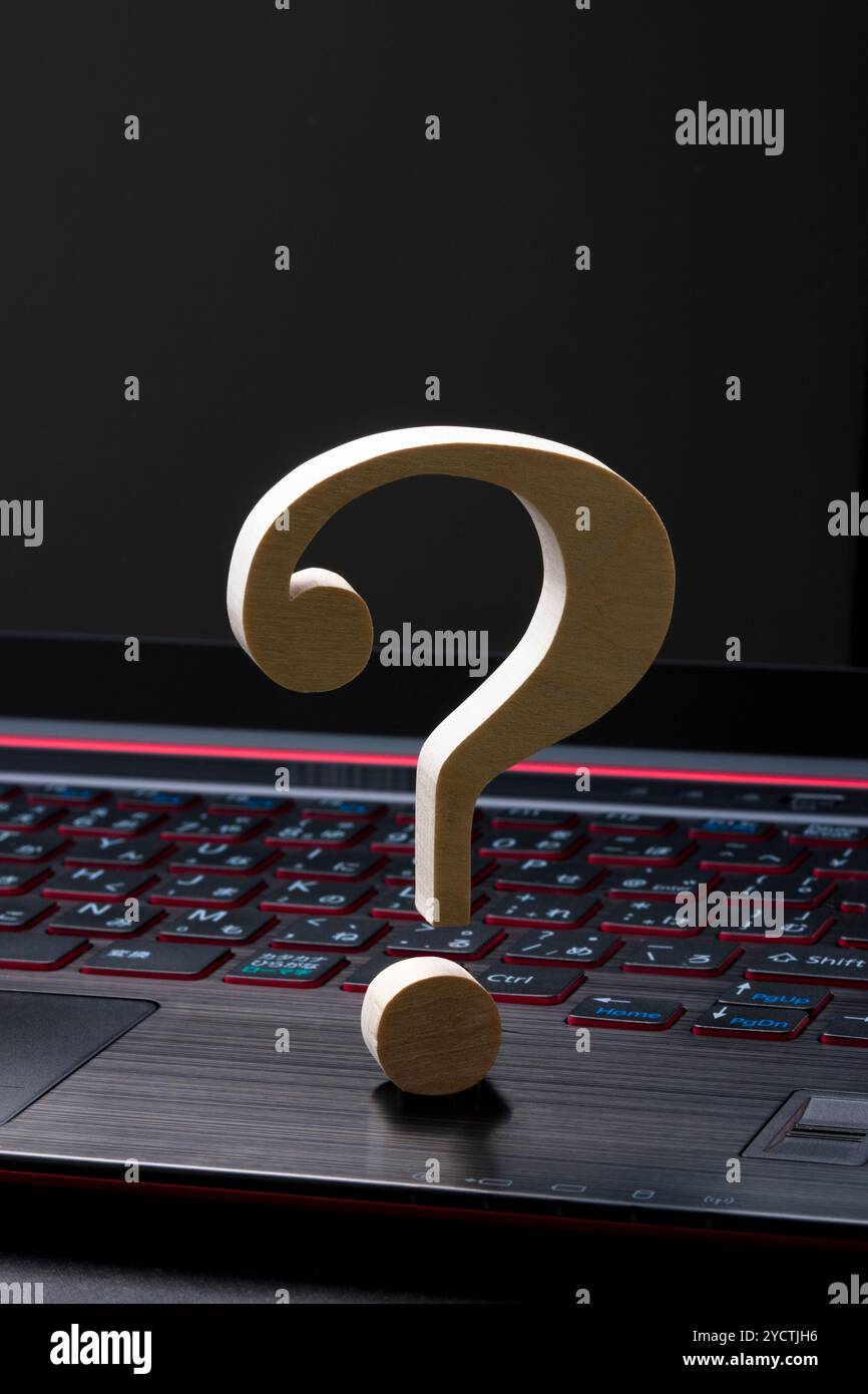 Wood-carved question mark and laptop Stock Photo - Alamy