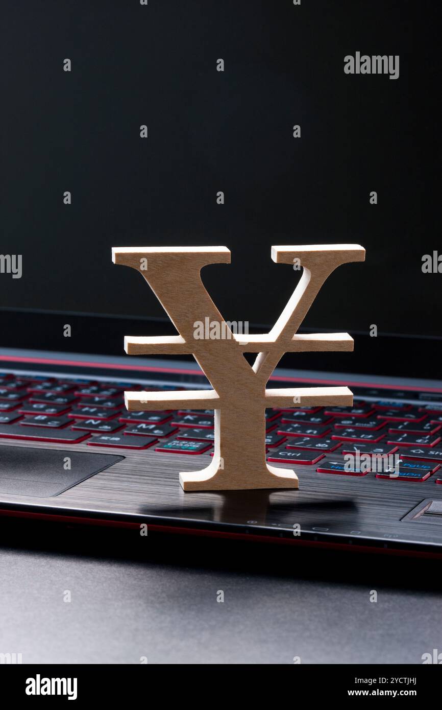 Wooden carved circular symbol and laptop computer Stock Photo - Alamy