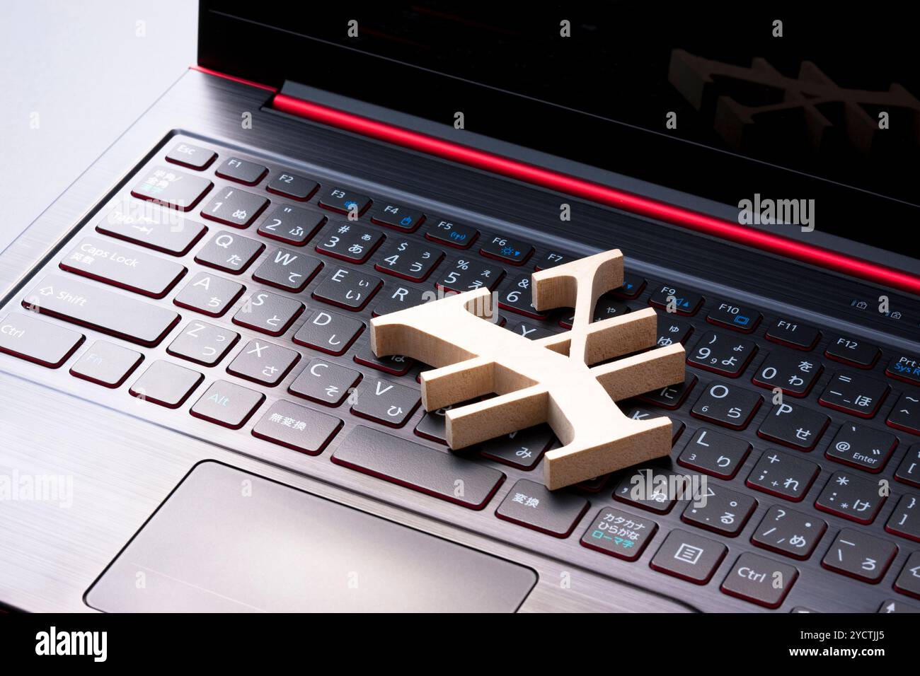 Wooden carved circular symbol and laptop computer Stock Photo - Alamy