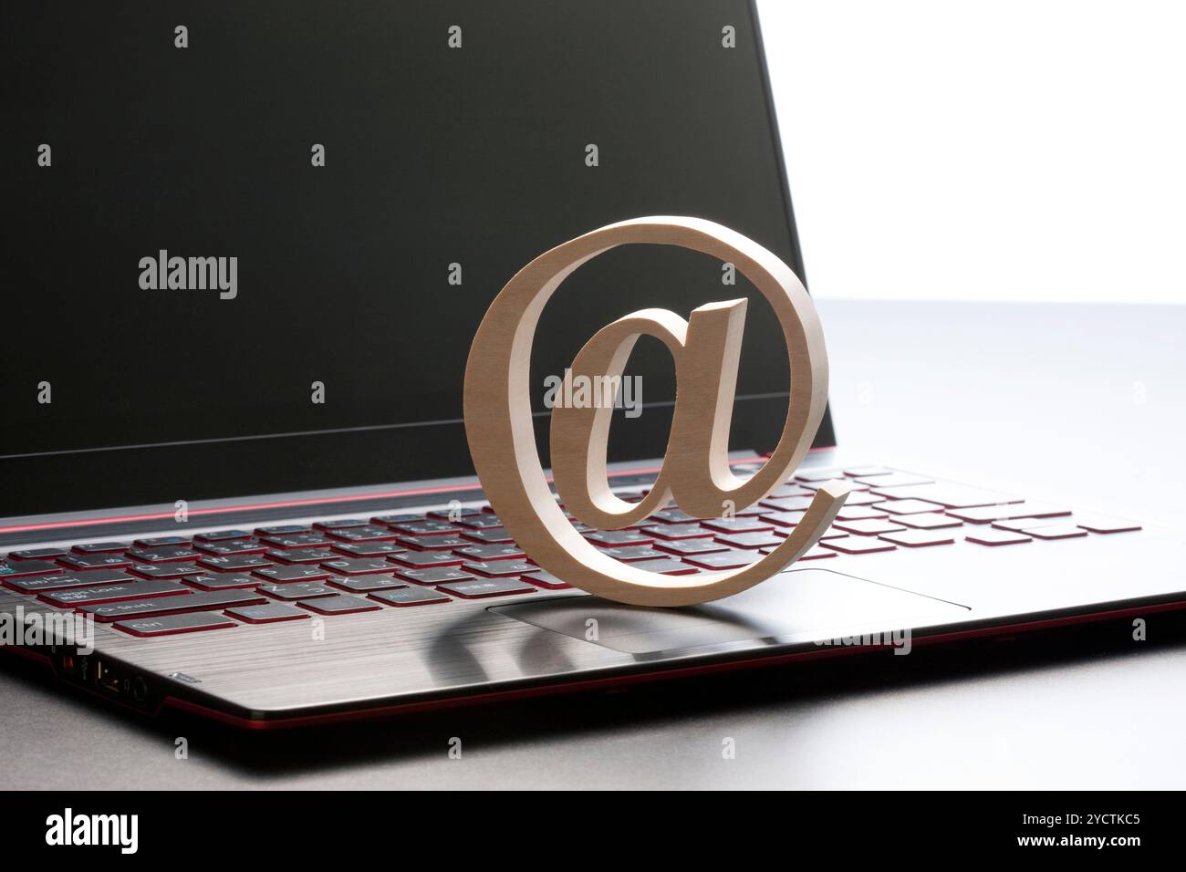 Wood-carved atmark and laptop Stock Photo - Alamy