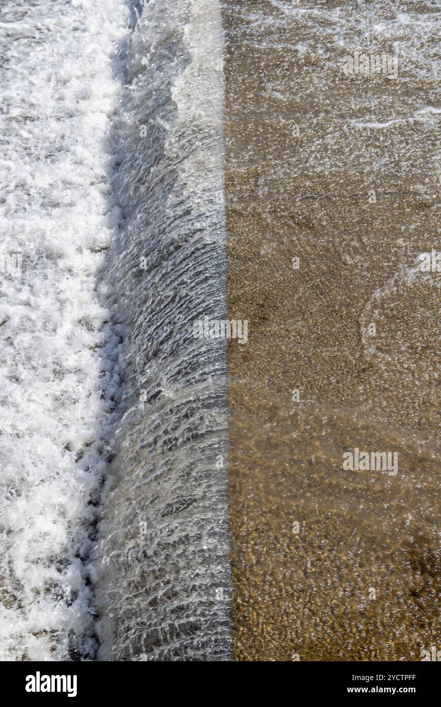 water falling from cascade edge of concrete water spillway channel ...