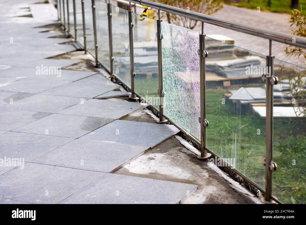A stainless steel railing featuring a glass panel installed on it ...