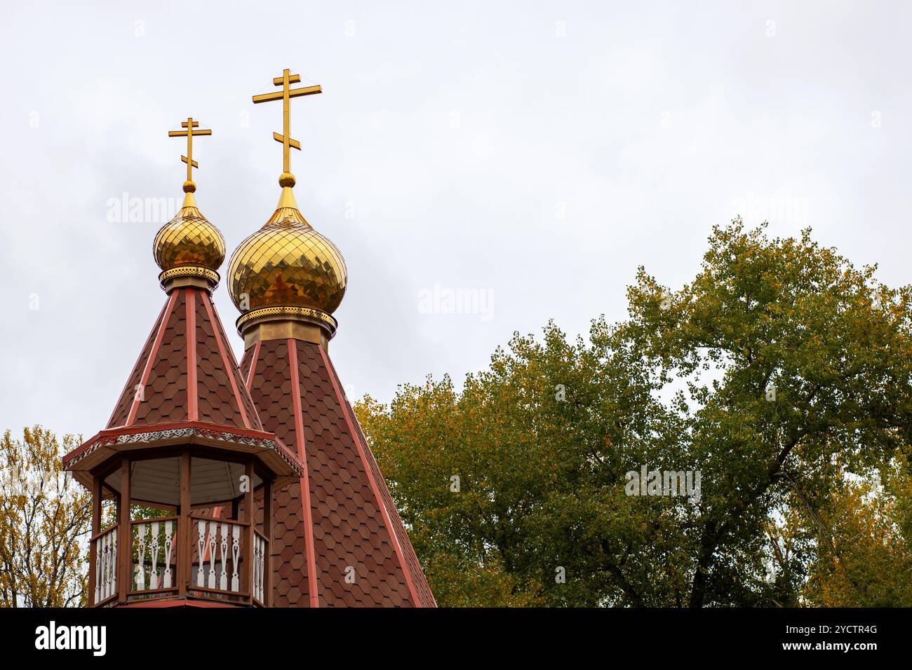 There is a church building adorned with two gold crosses prominently ...