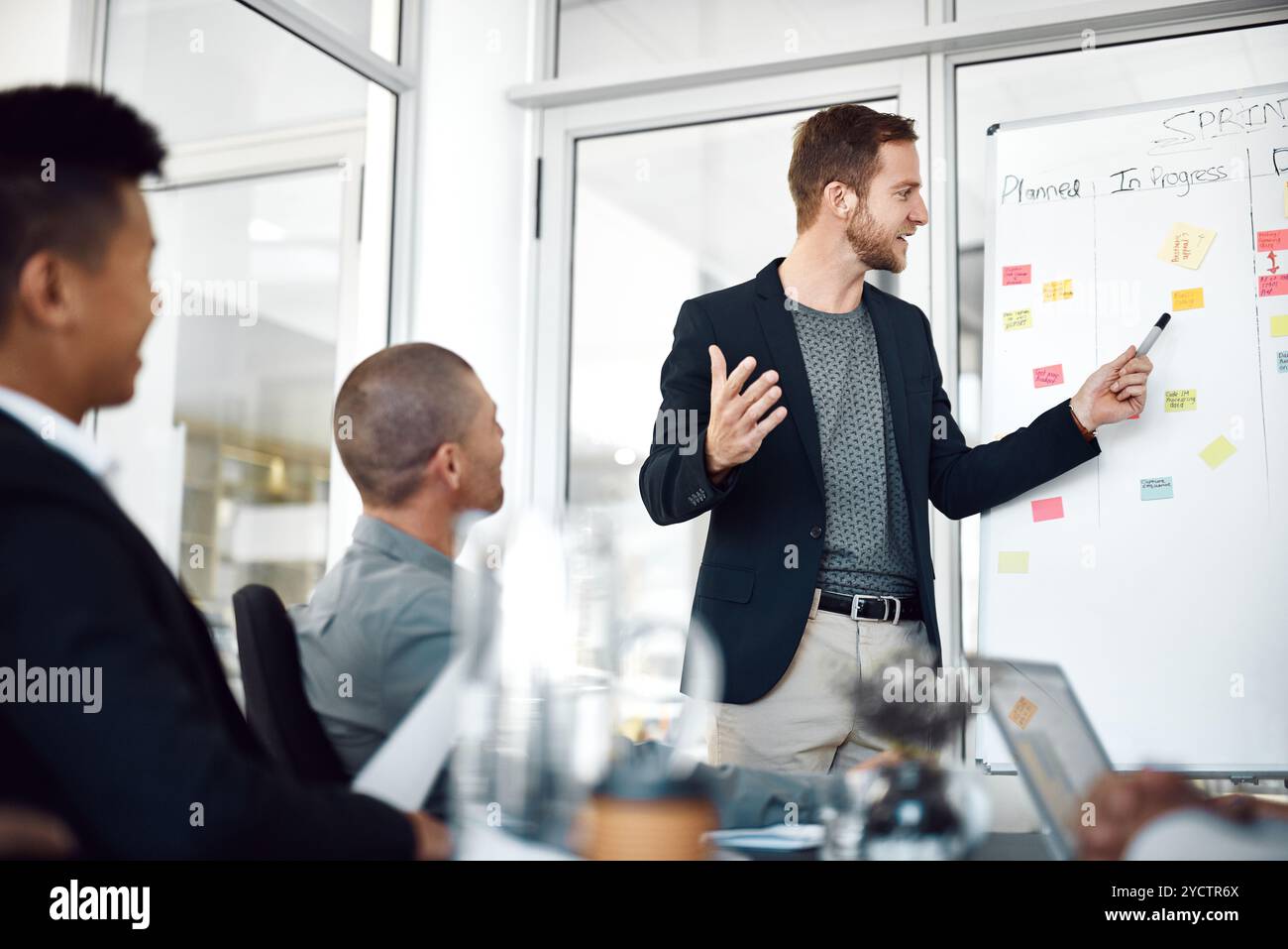 Employees, whiteboard and sticky notes for meeting in office, planning ...