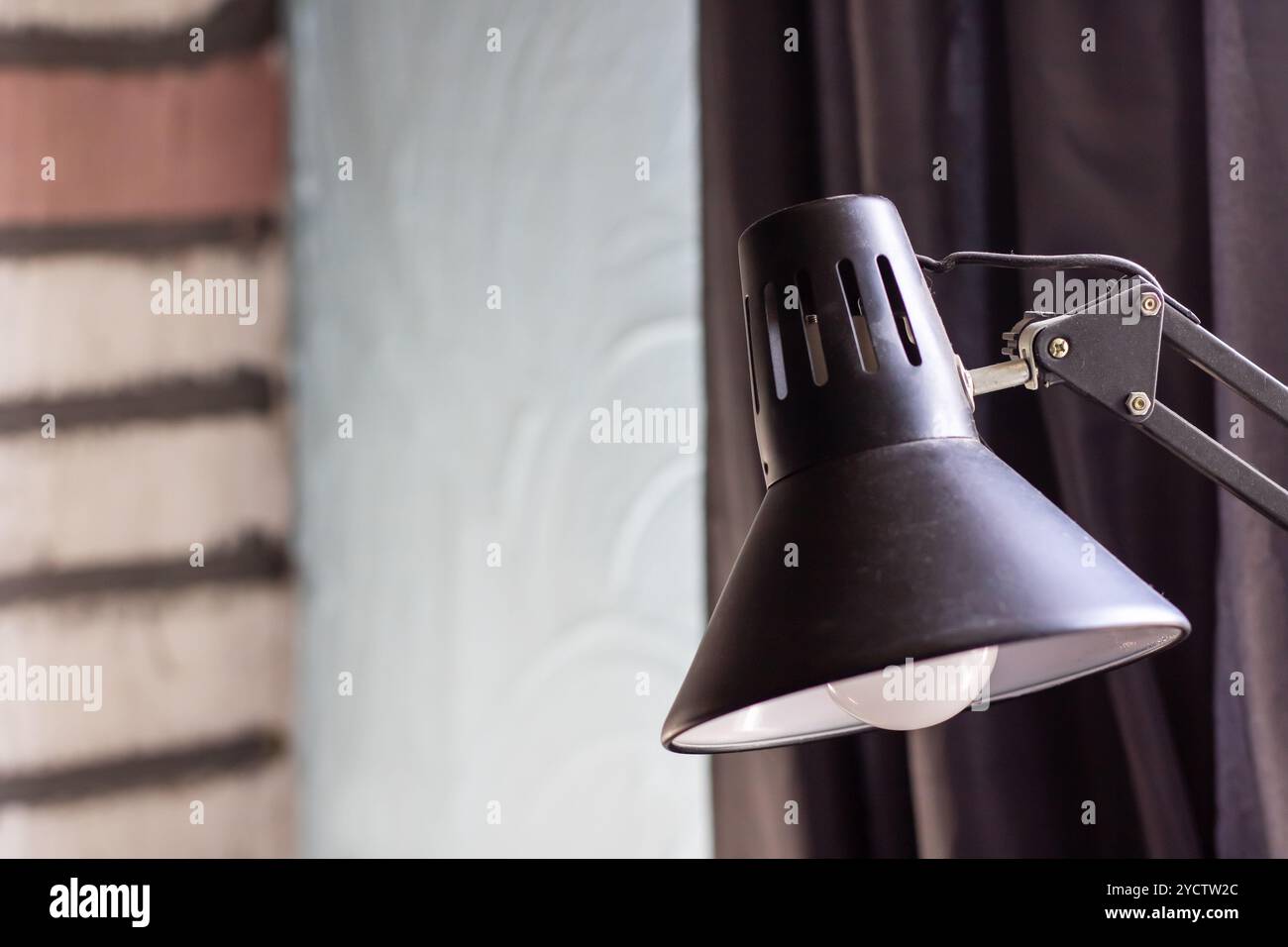 This image showcases a closeup view of a stylish black lamp featuring ...