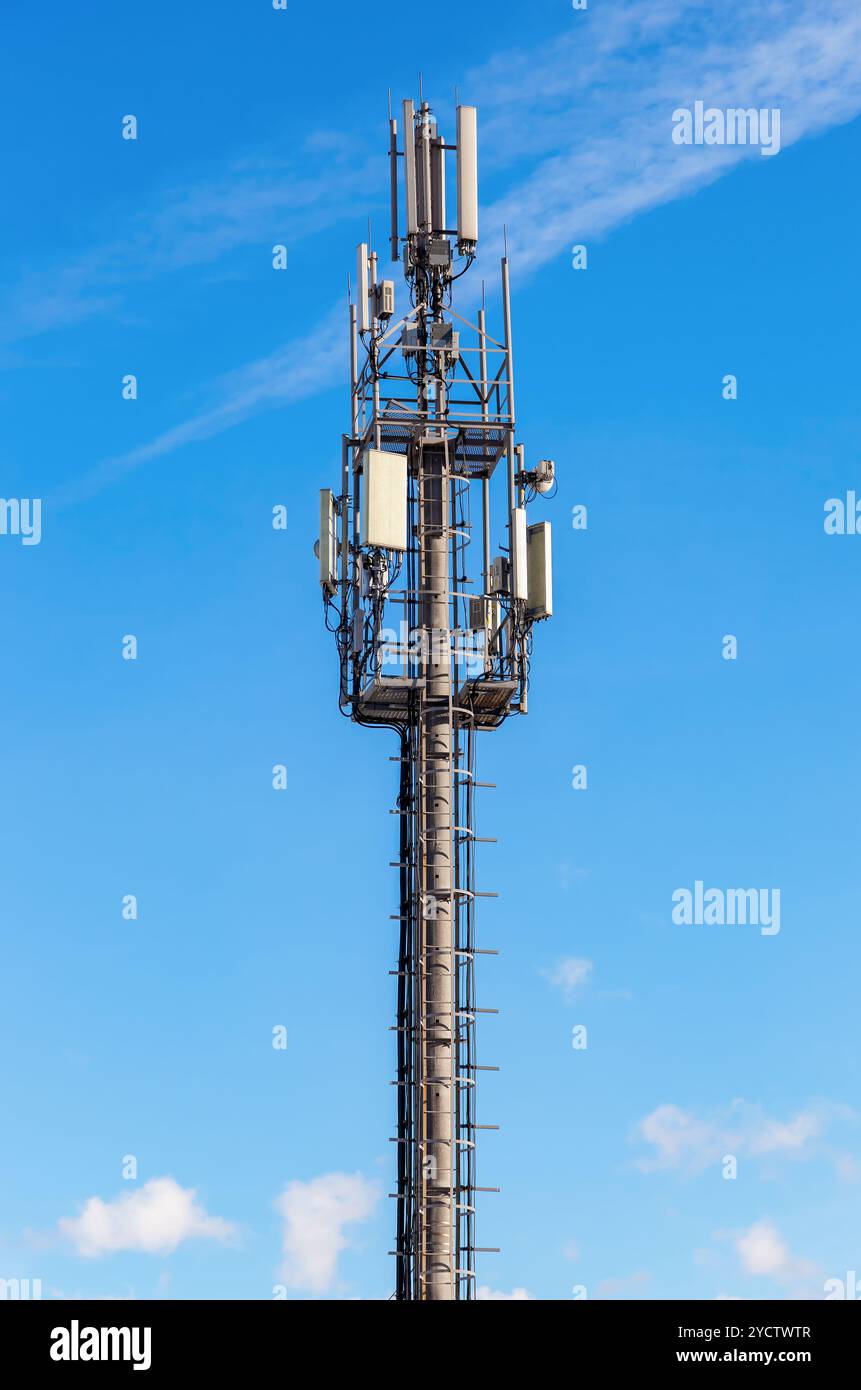 Telecommunication tower for mobile phone with antennas over a blue sky. Distribution function of ...