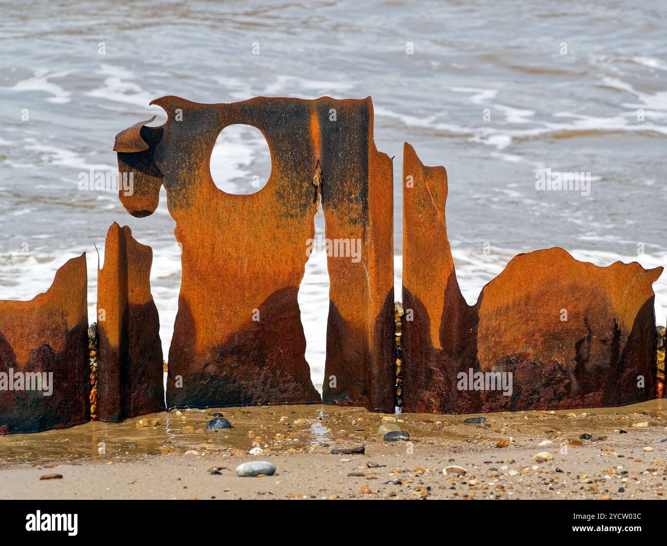 Rusting remains of a destroyed groyne formed of steel piling at ...