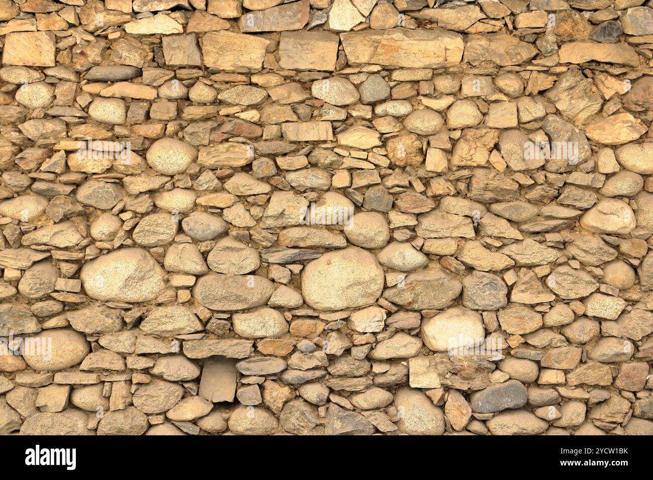 a yellow beige sand color stone brick vertical wall Stock Photo - Alamy