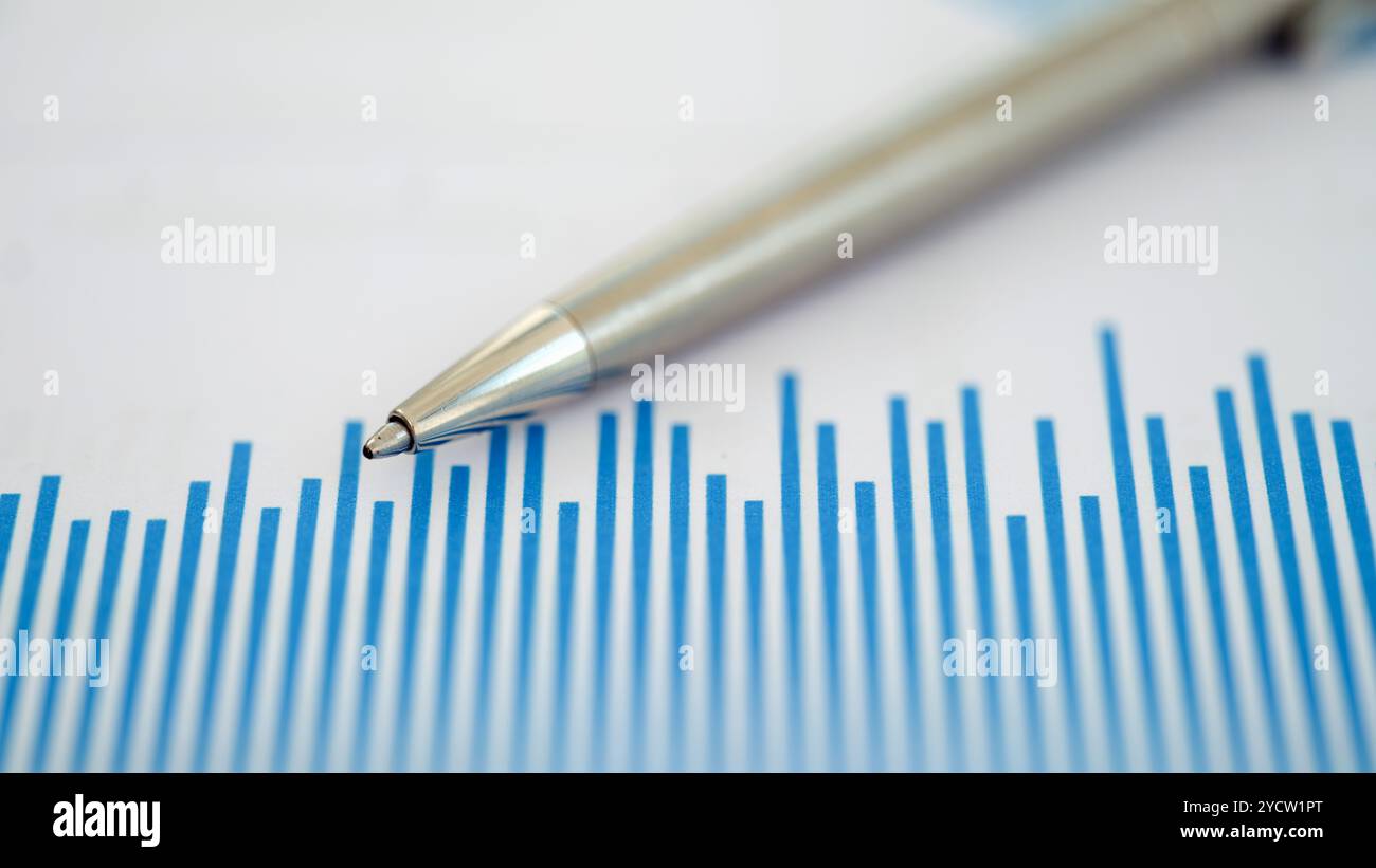 Conducting a thorough analysis of financial trends by using a pen to ...