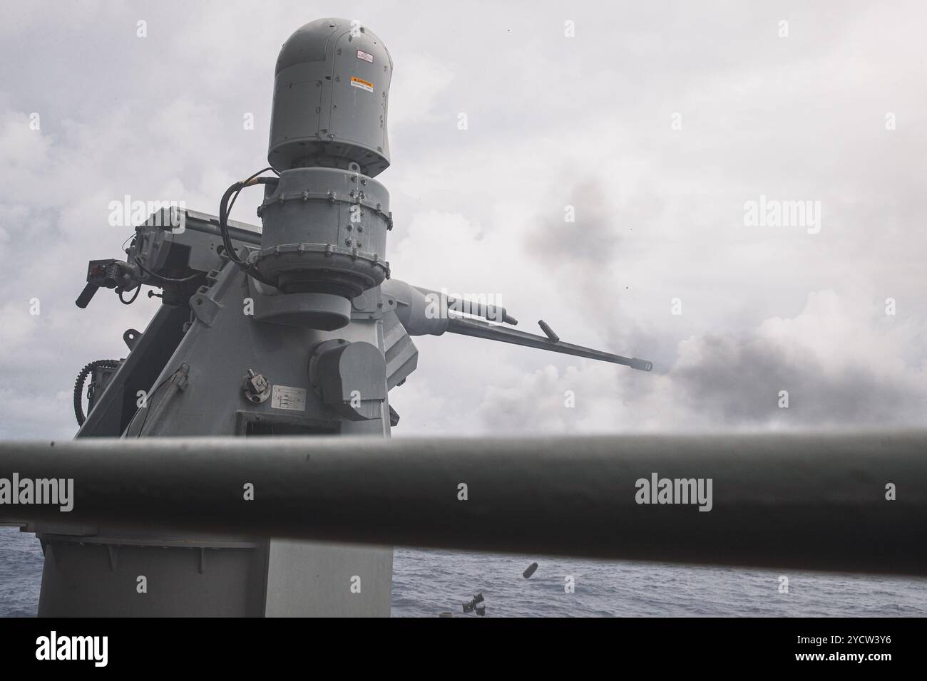 A Mark-38 25mm gun mount fires at a simulated target from the fantail ...