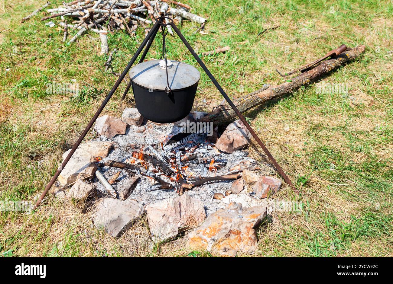 Cooking food over an open fire at the campsite in summer sunny day ...