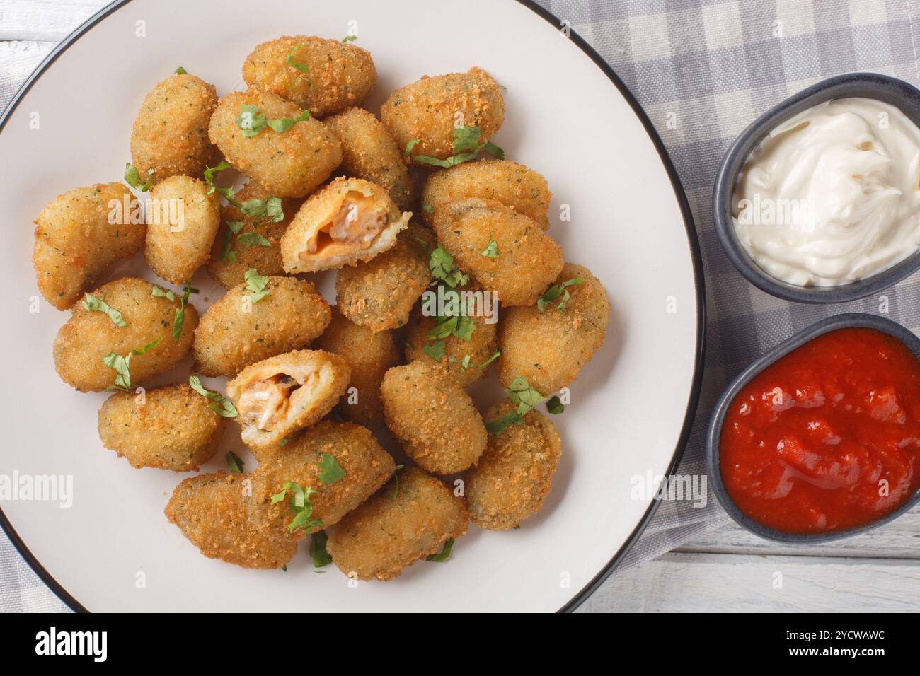 Deep fried breaded mussels served with mayonnaise and ketchup close-up ...