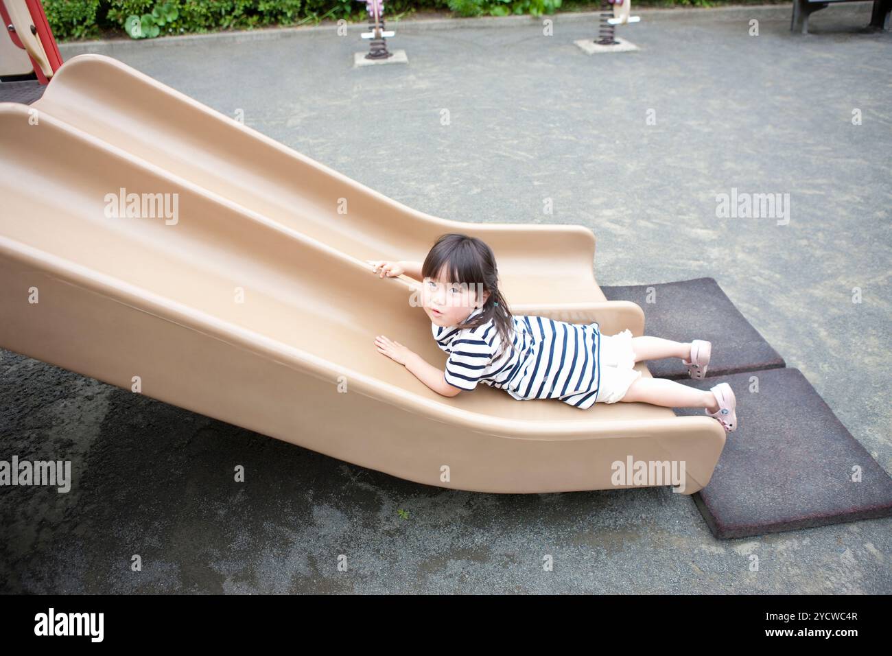 Girl playing on the slide Stock Photo - Alamy