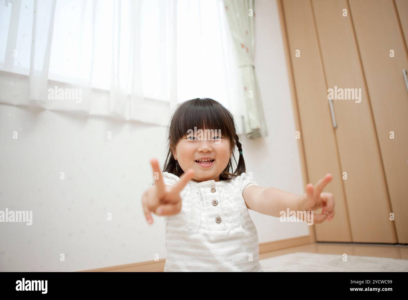 Girl making peace sign Stock Photo - Alamy