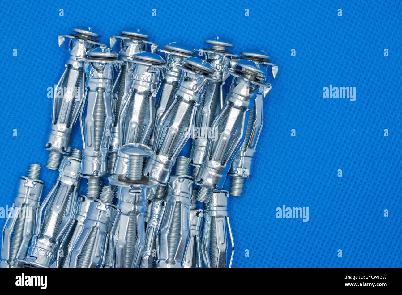 Many metal dowels for quick installation lying on blue background are ...