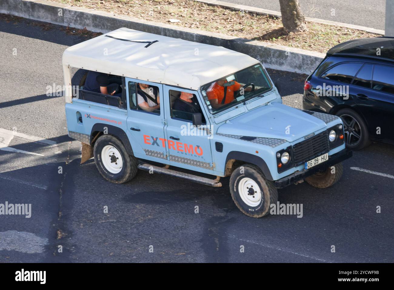 Blue customized land rover defender 110 driving in the city for tourist ...