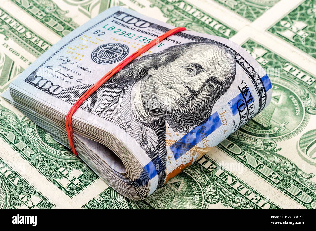 Folded american dollar bills wrapped by rubber band over dollars ...