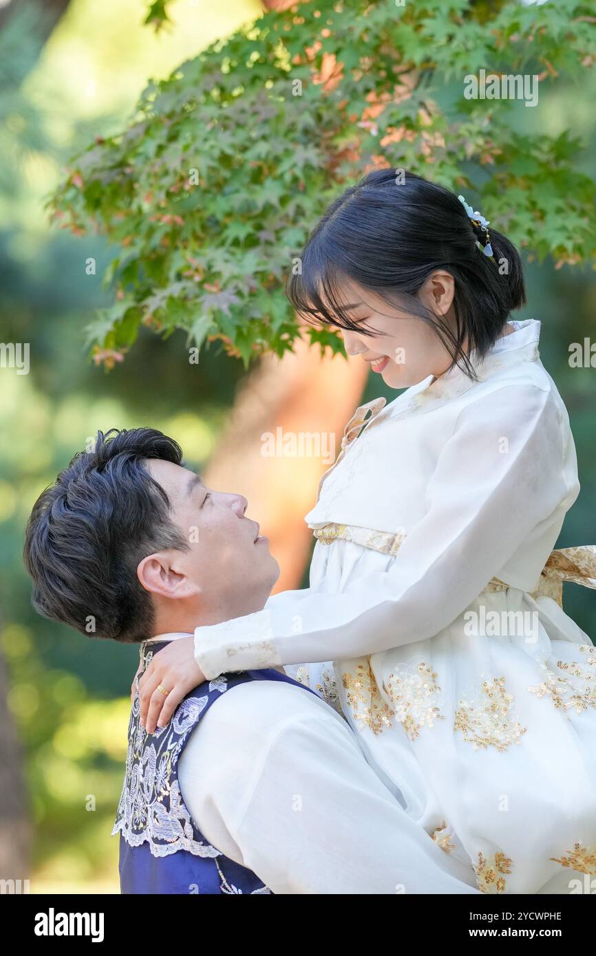 A Korean couple, a man in his 30s and a woman in her 20s, are wearing ...