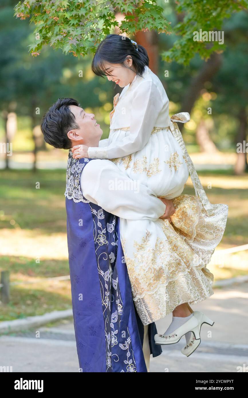 A Korean couple, a man in his 30s and a woman in her 20s, are wearing ...