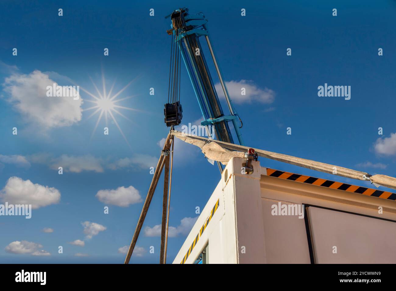 hoisting solutions hydraulic crane lifting a container , blue sky as ...