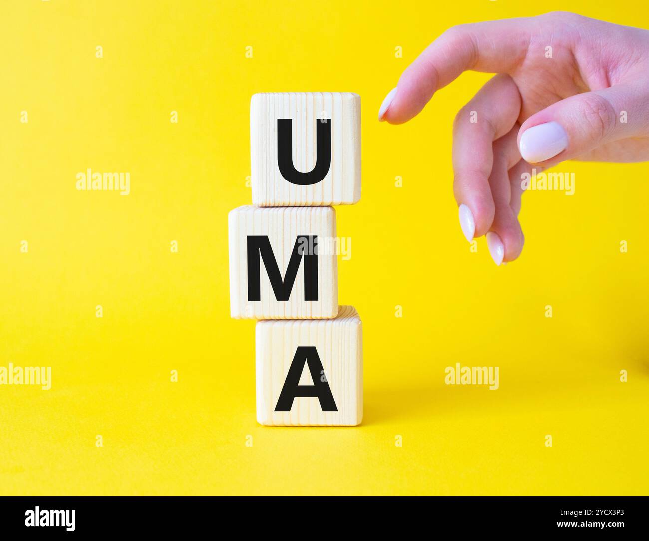 UMA - Unified Managed Account. Wooden cubes with word UMA. Businessman ...