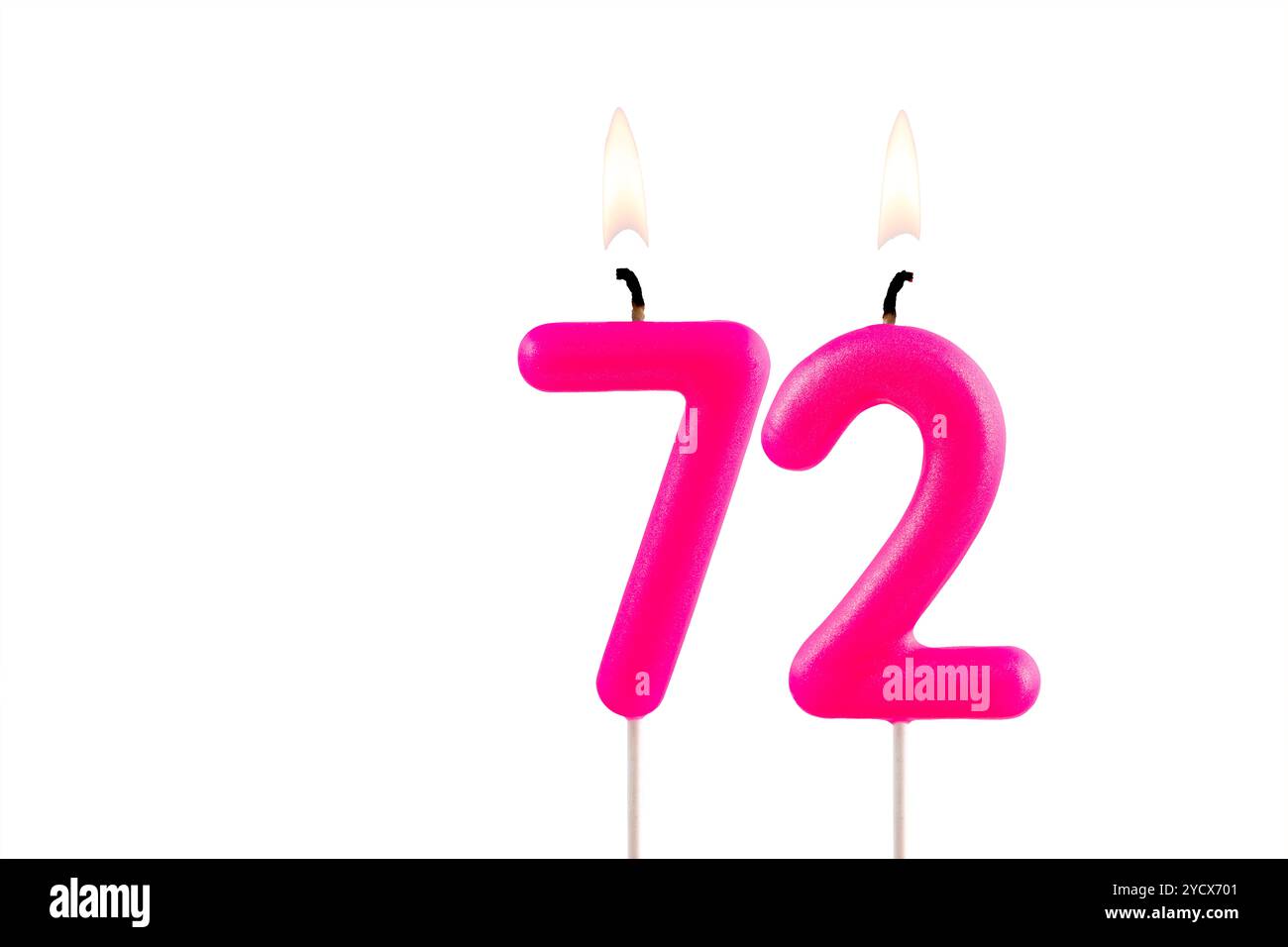 Pink number 72 birthday candle lit on white background Stock Photo - Alamy