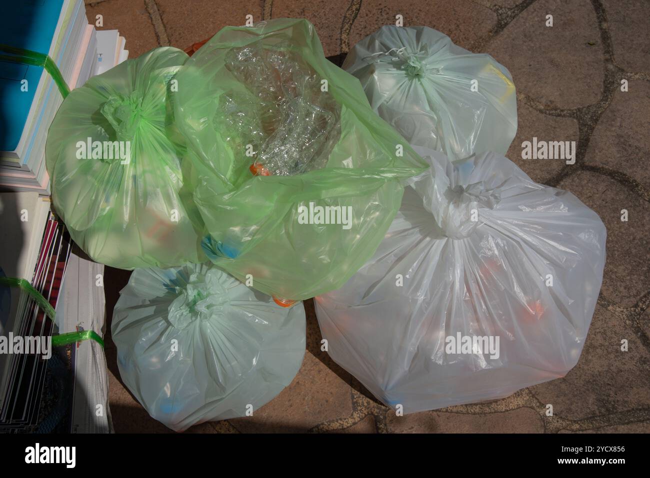 Overhead view of several tied plastic bags filled with recyclable items ...