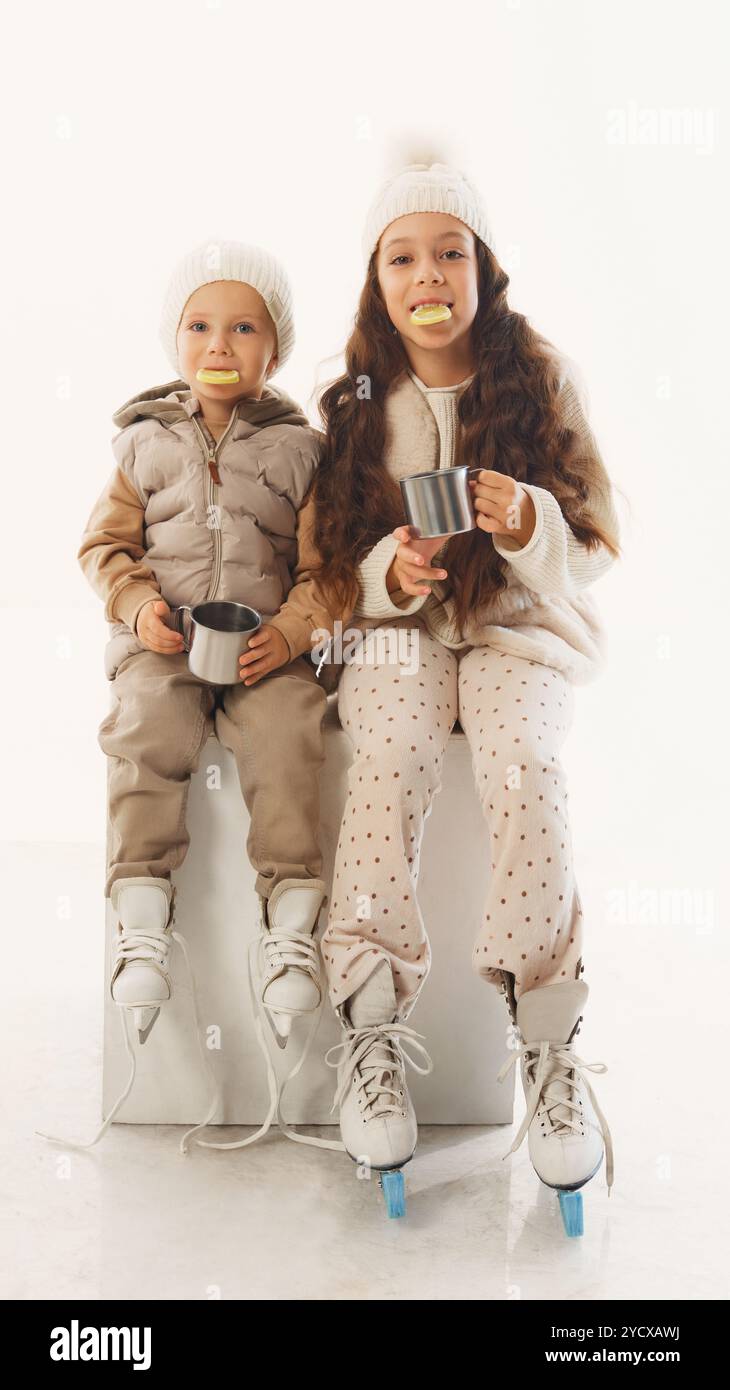 Brother and sister have fun sharing their snack, making silly faces as ...