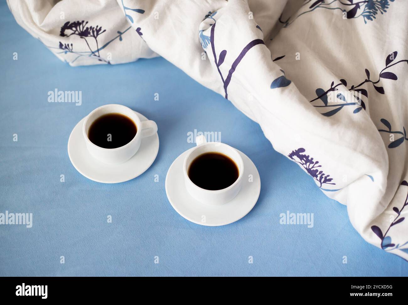 Two white cups of coffee are in bed Stock Photo - Alamy