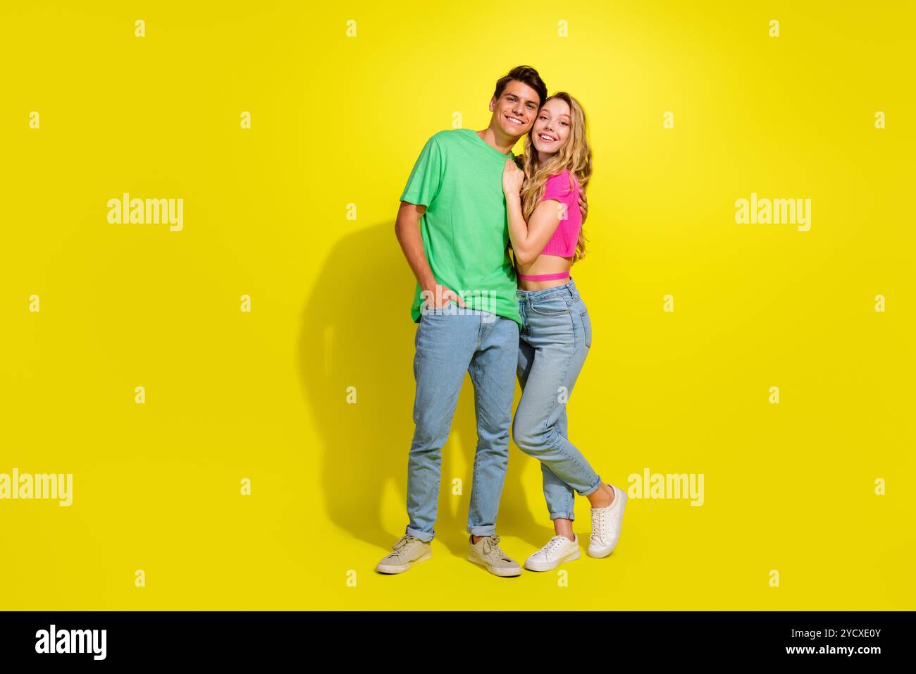 Full body portrait of two nice young partners embrace empty space ...