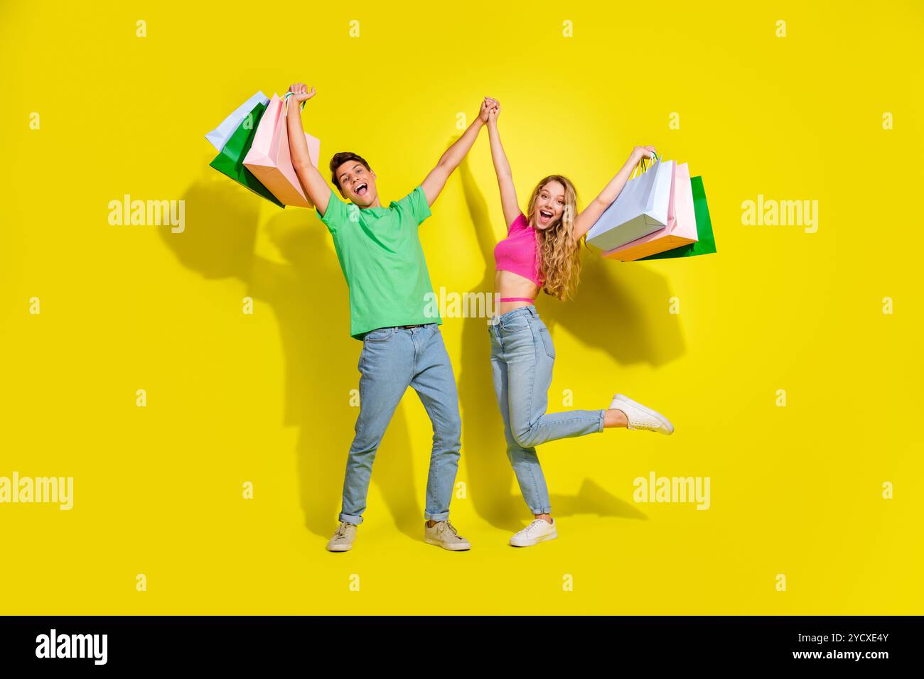 Full body portrait of two nice young partners hold hands bags isolated ...