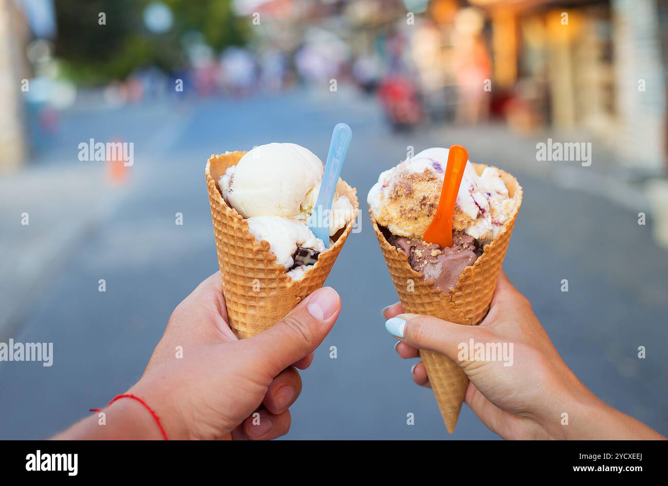 Beautiful bright ice cream with different flavors in the hands of a ...
