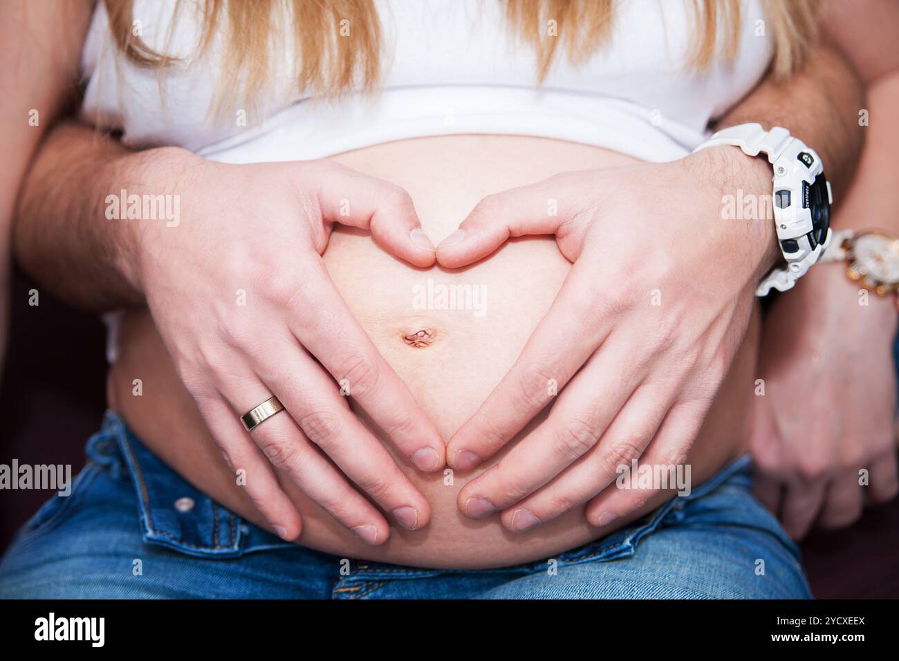 Pregnant Belly with fingers Heart symbol Stock Photo - Alamy