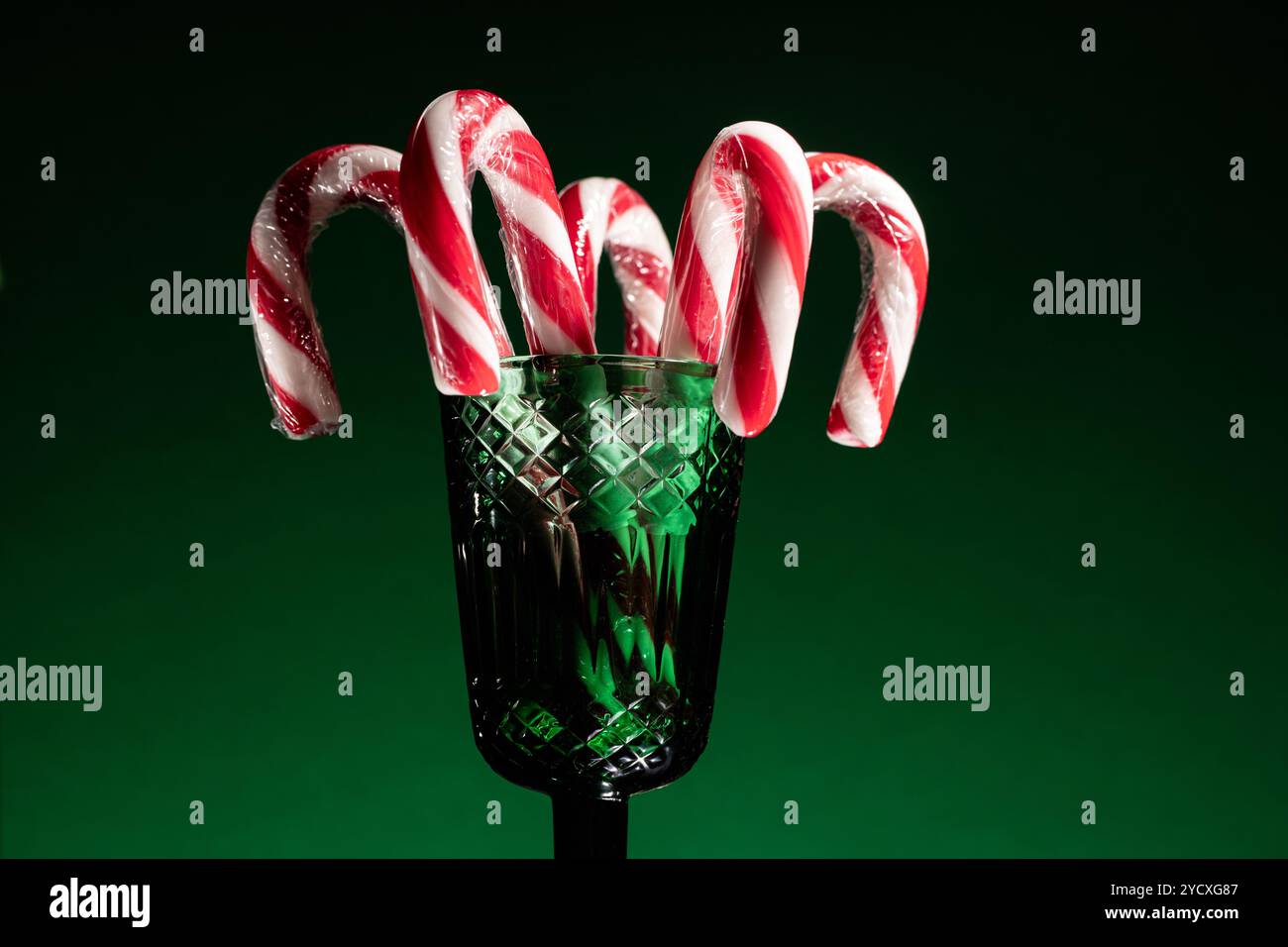 A festive display of shiny red and white striped candy canes arranged ...