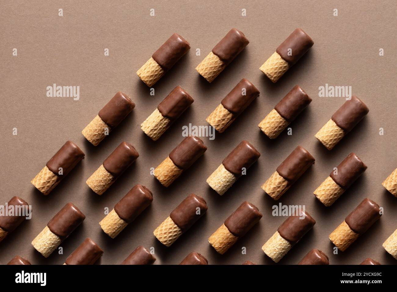 Top view of neatly arranged rows of chocolate-coated wafers on a smooth ...