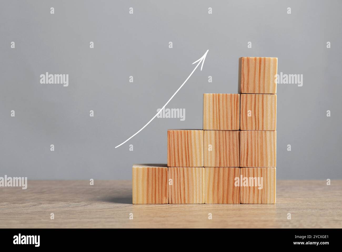 Stair of wooden cubes and arrow on grey background. Step-by-step ...