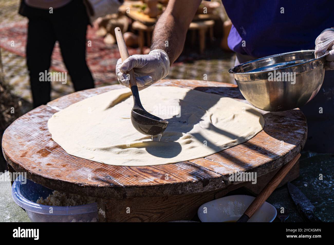 A skilled baker crafts traditional Georgian cheese bread, khachapuri ...