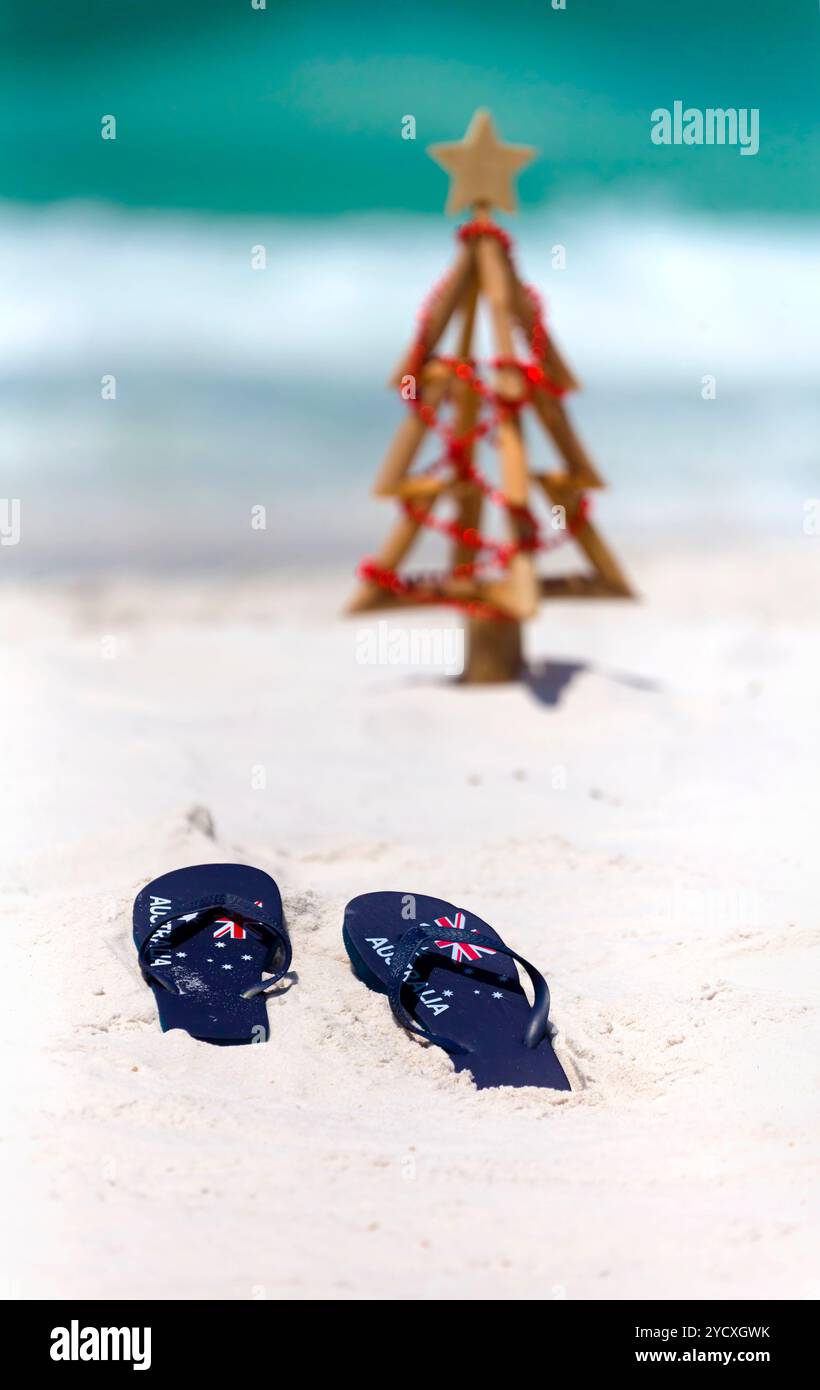 Australia flag thongs in focus with a small diriftwood Christmas tree ...
