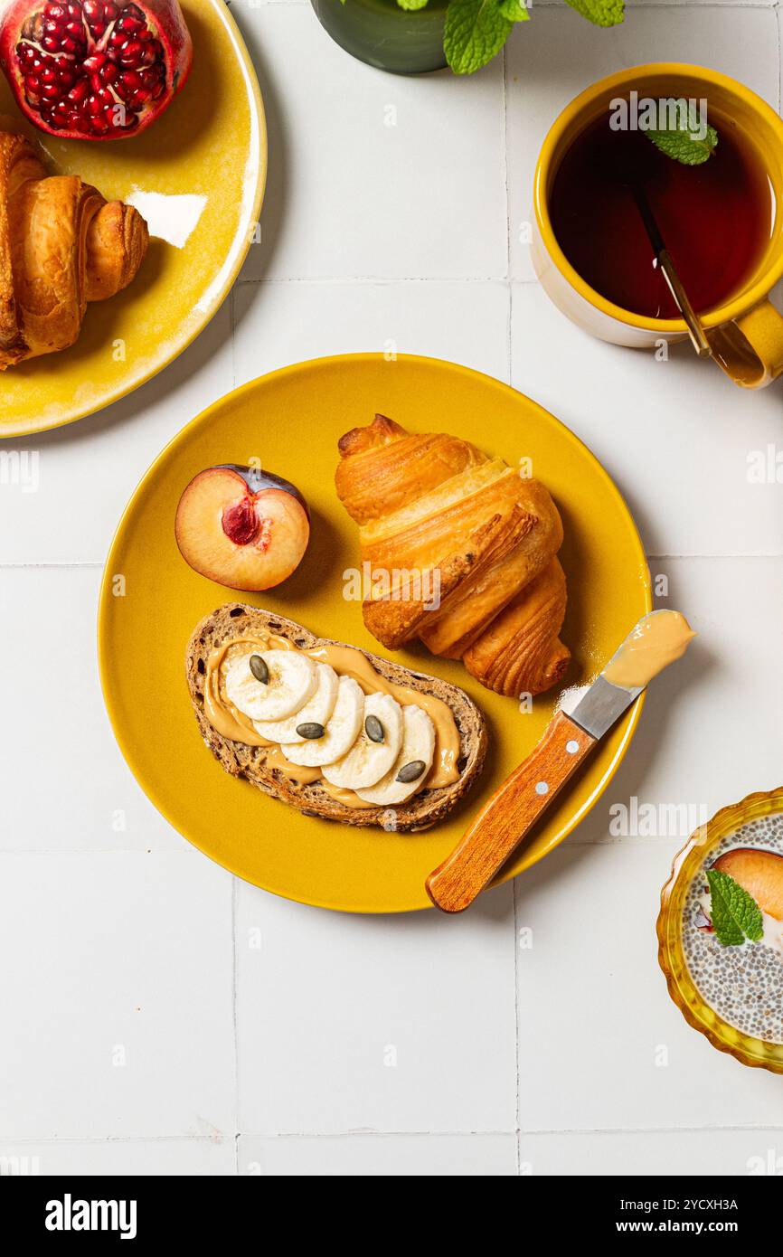 A vibrant breakfast layout featuring yellow plates with croissants ...