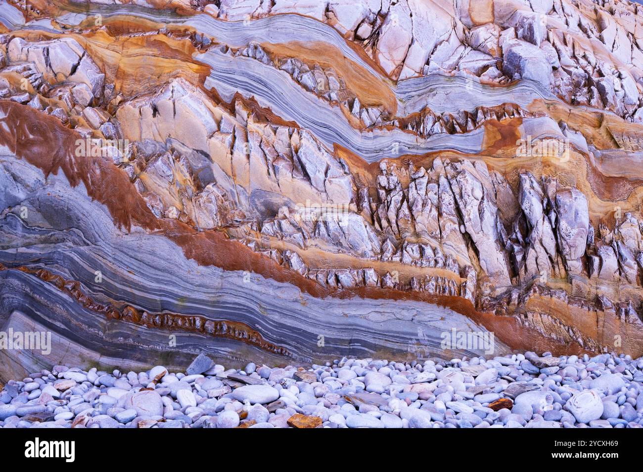 Variegated sedimentary rock layers and smooth pebbles seen on the ...