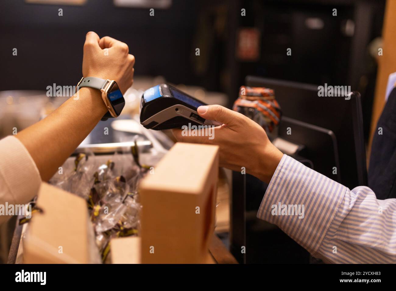 Customer making a contactless payment using a smartwatch at a chocolate ...
