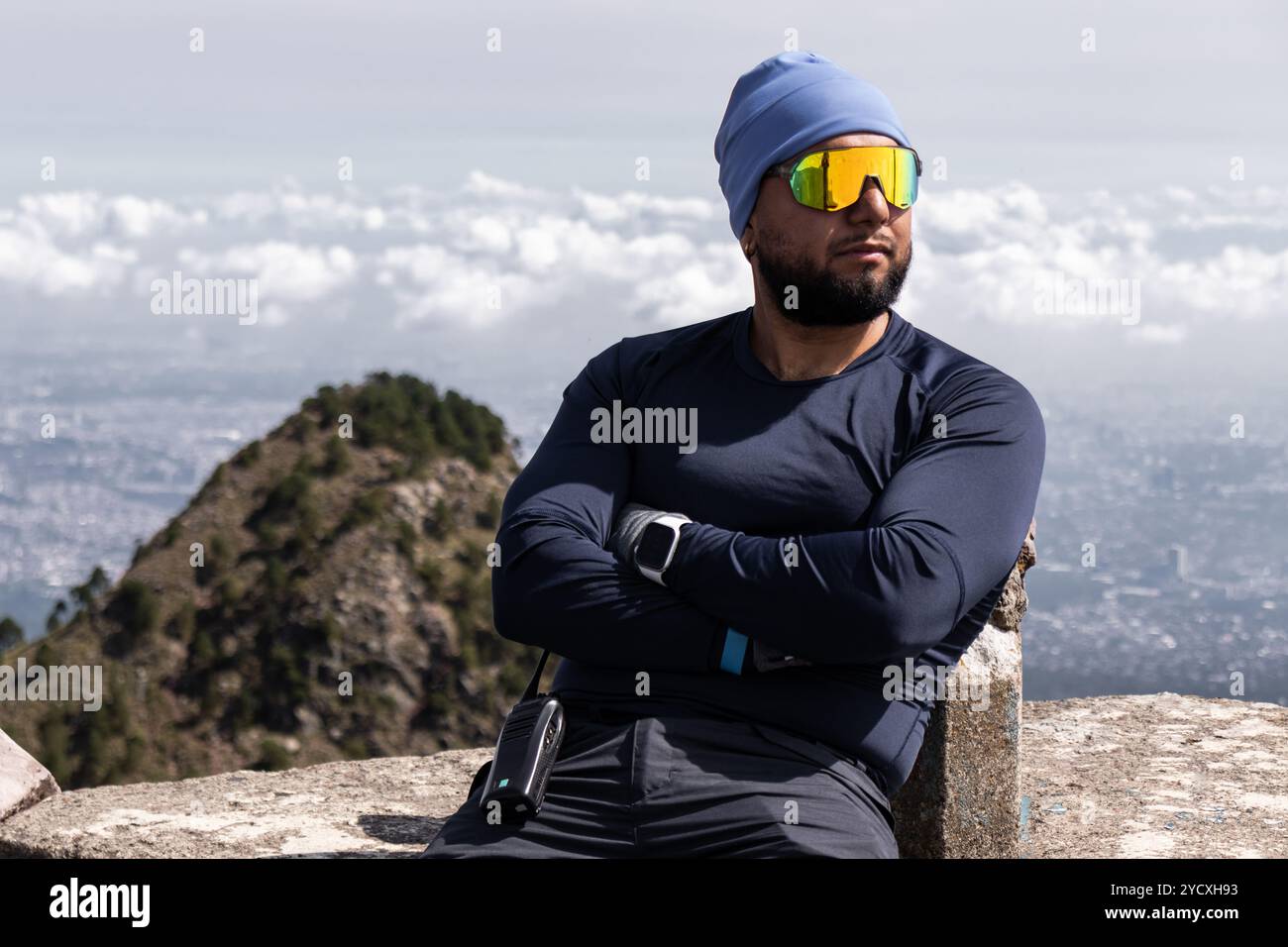 Black man, wearing sunglasses, pauses on a hike to enjoy the expansive ...