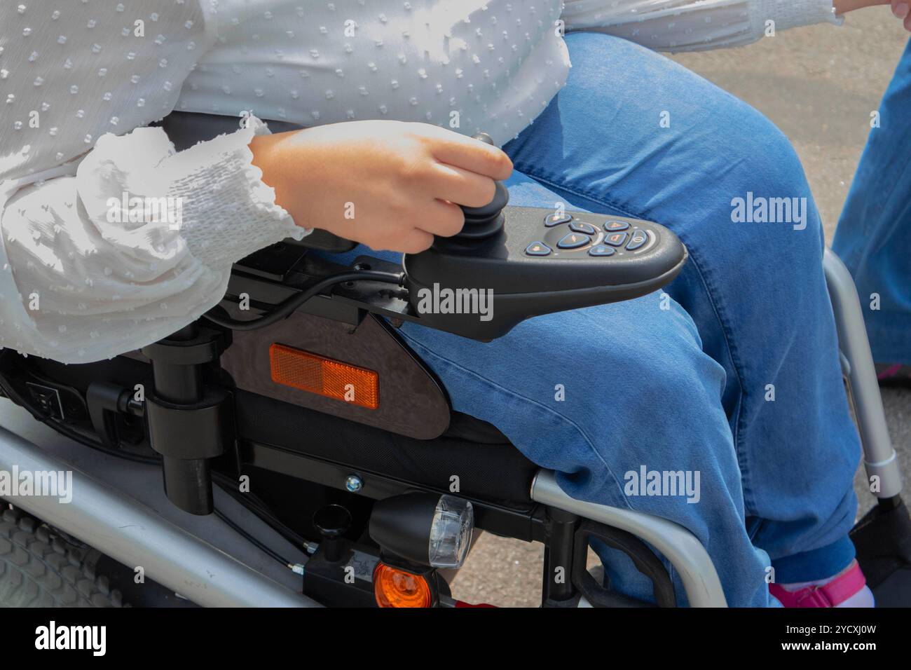 Close-up view of a young girl's hand operating the joystick of her ...