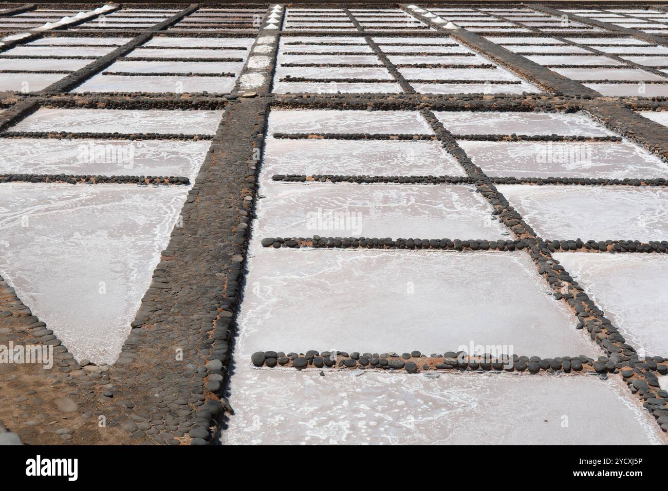 An aerial image showcasing traditional salt pans, defined by stone ...