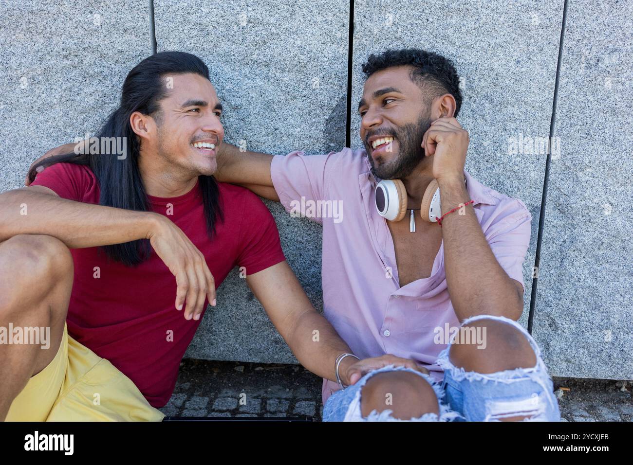 Gay couple, showcasing diverse cultural backgrounds Seated against a ...